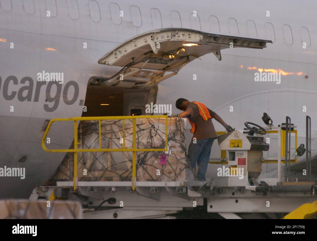 Ramp workers manage the loading of freight onto a cargo plane at Miami ...