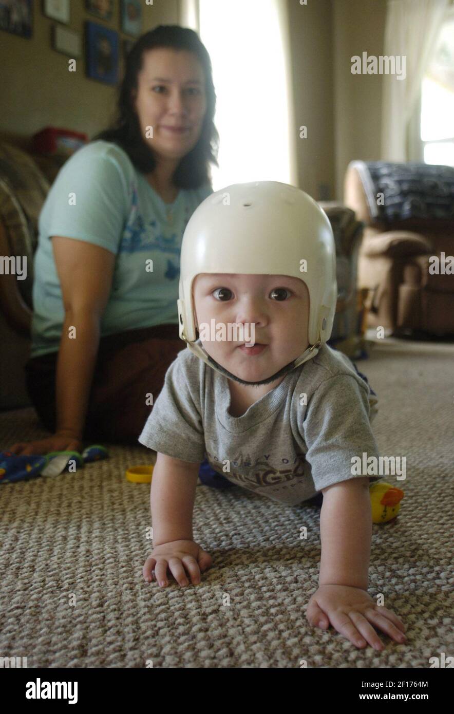 Eva Milne, background, watches her son Andrei Milne, 7 months, crawl ...