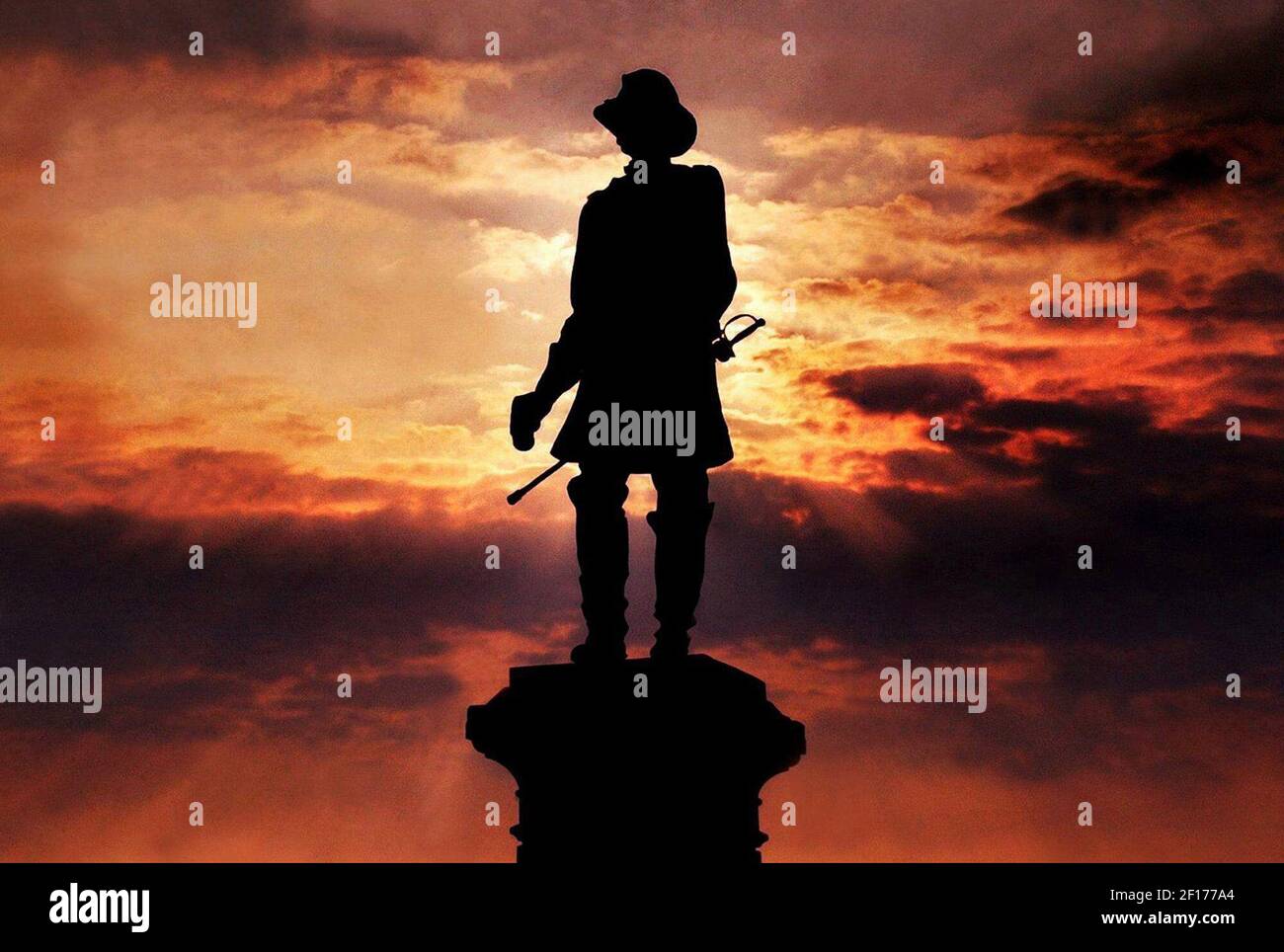 A rising sun creates a brilliant glow around the statue of general John ...