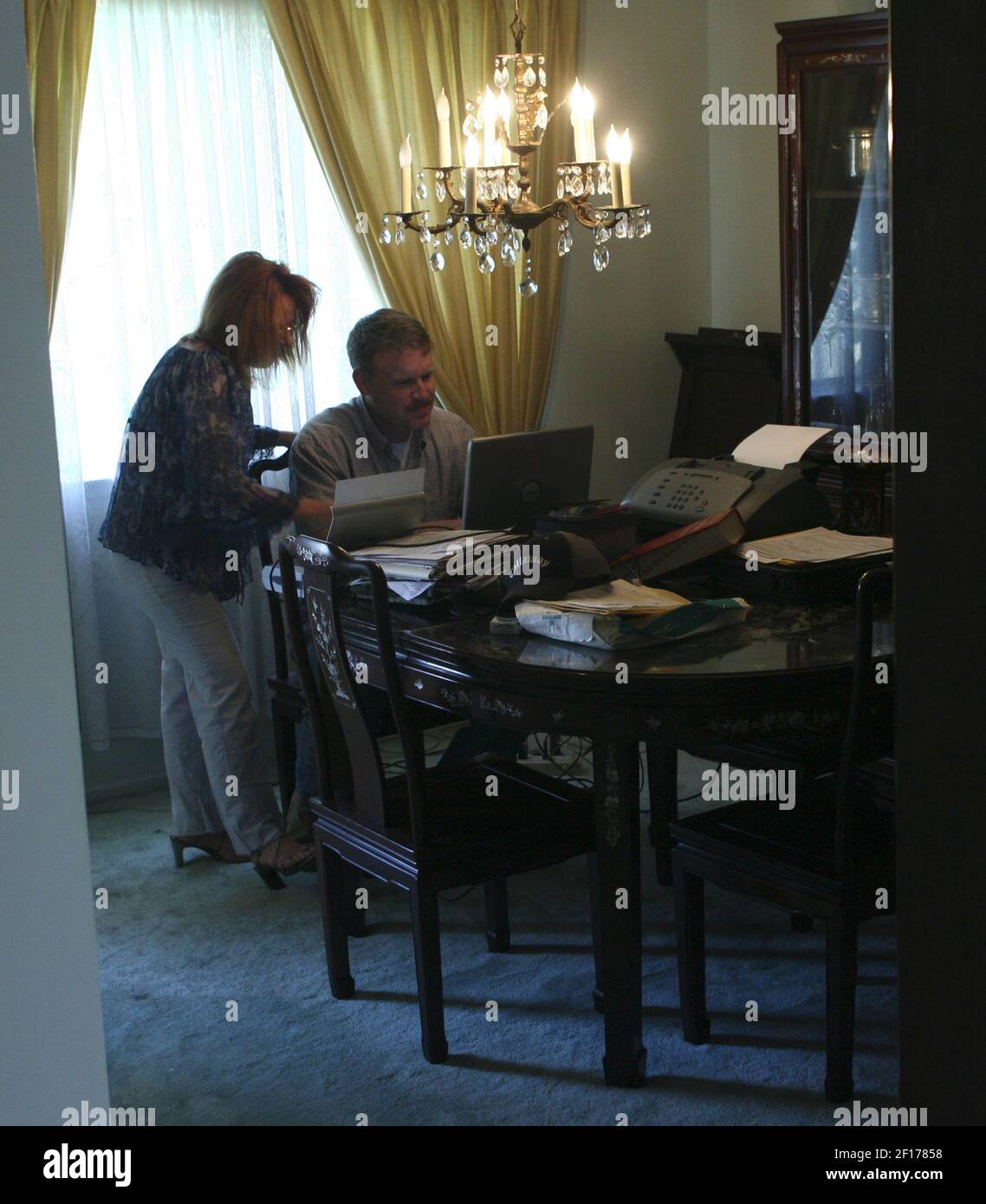 Karen McGraw helps her husband put together a new resume. John retured ...