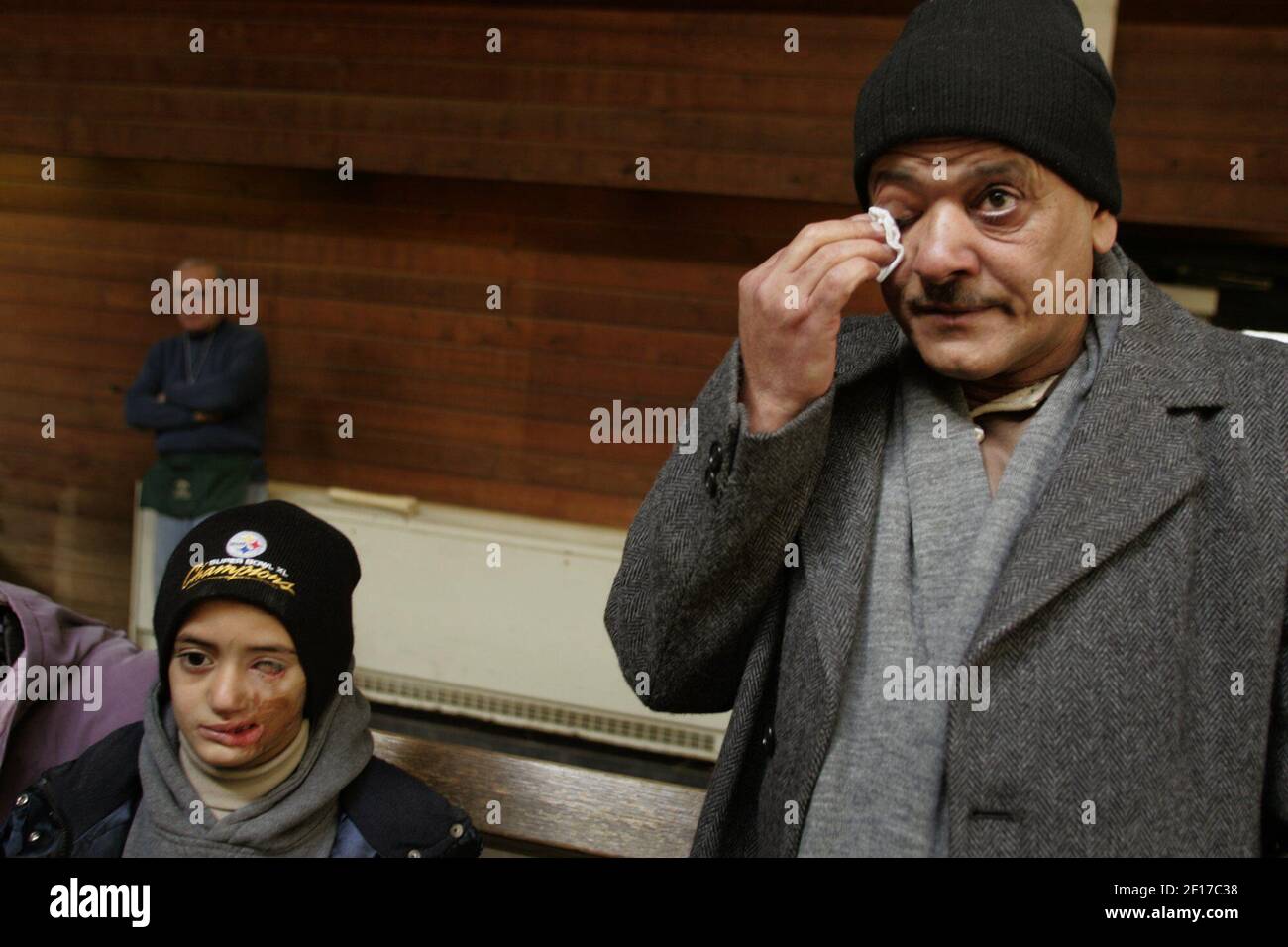 Ismael Khalaf Hussein, right, wipes his eyes while his son Abdul Hakim ...