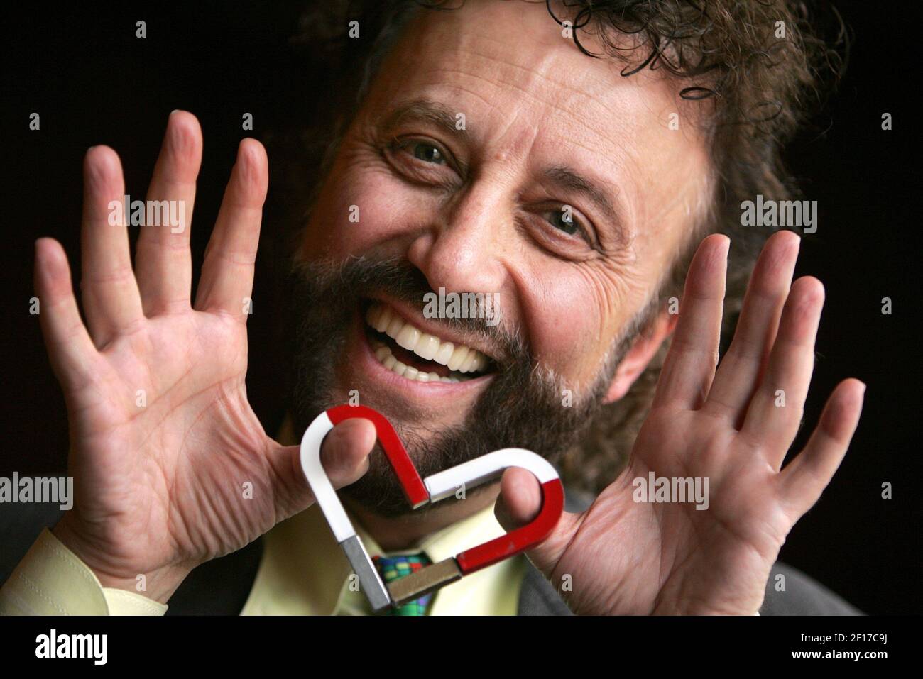 Russian comedian Yakov Smirnoff holds his prop of magnets connected in ...