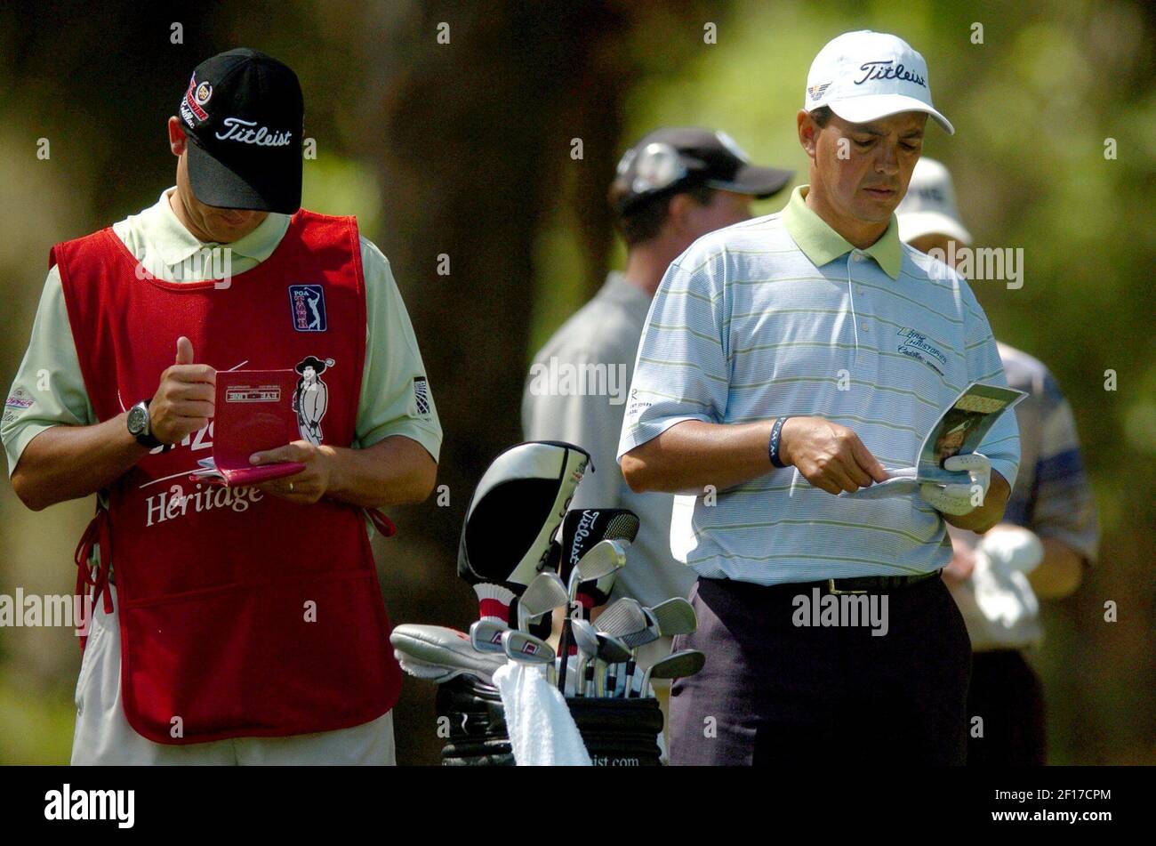 Tom Pernice Jr., right, and his caddie Chad Reynolds, left, go through ...