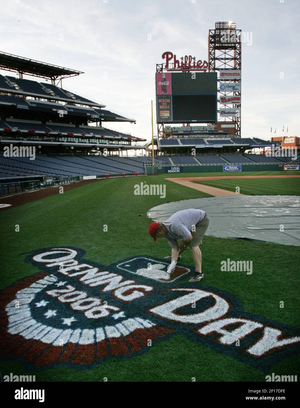 Philadelphia Phillies grounds crew member Jeremy Wilt puts on finishing ...