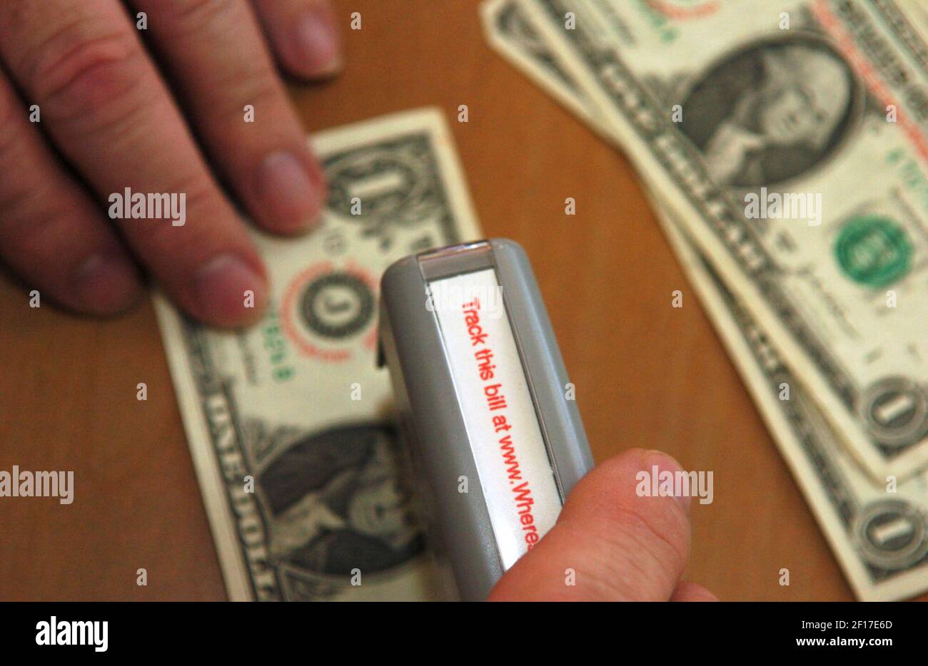 John Fleps, of Celebration, Florida, stamps dollars, May 12, 2006, in ...