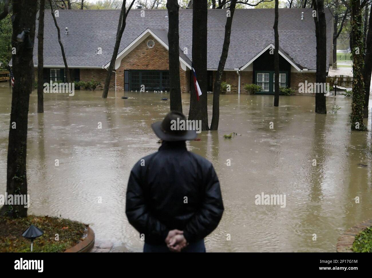 Nasser Gittiban watches as flood waters from Rush Creek overtake his ...