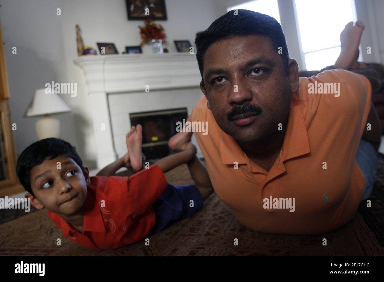Hari Subramanian stretches with his 6-year-old son, Vignesh, at his ...