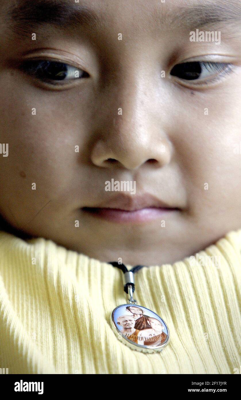 For good luck, Mee Yang, 9, wears a pendant featuring three Buddhist ...