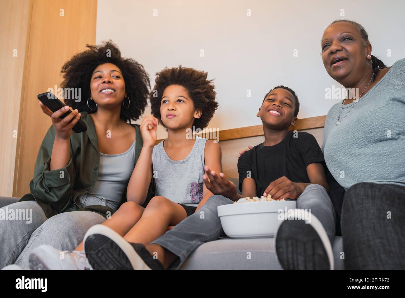 Grandmother, mother and children watching a movie at home Stock Photo ...