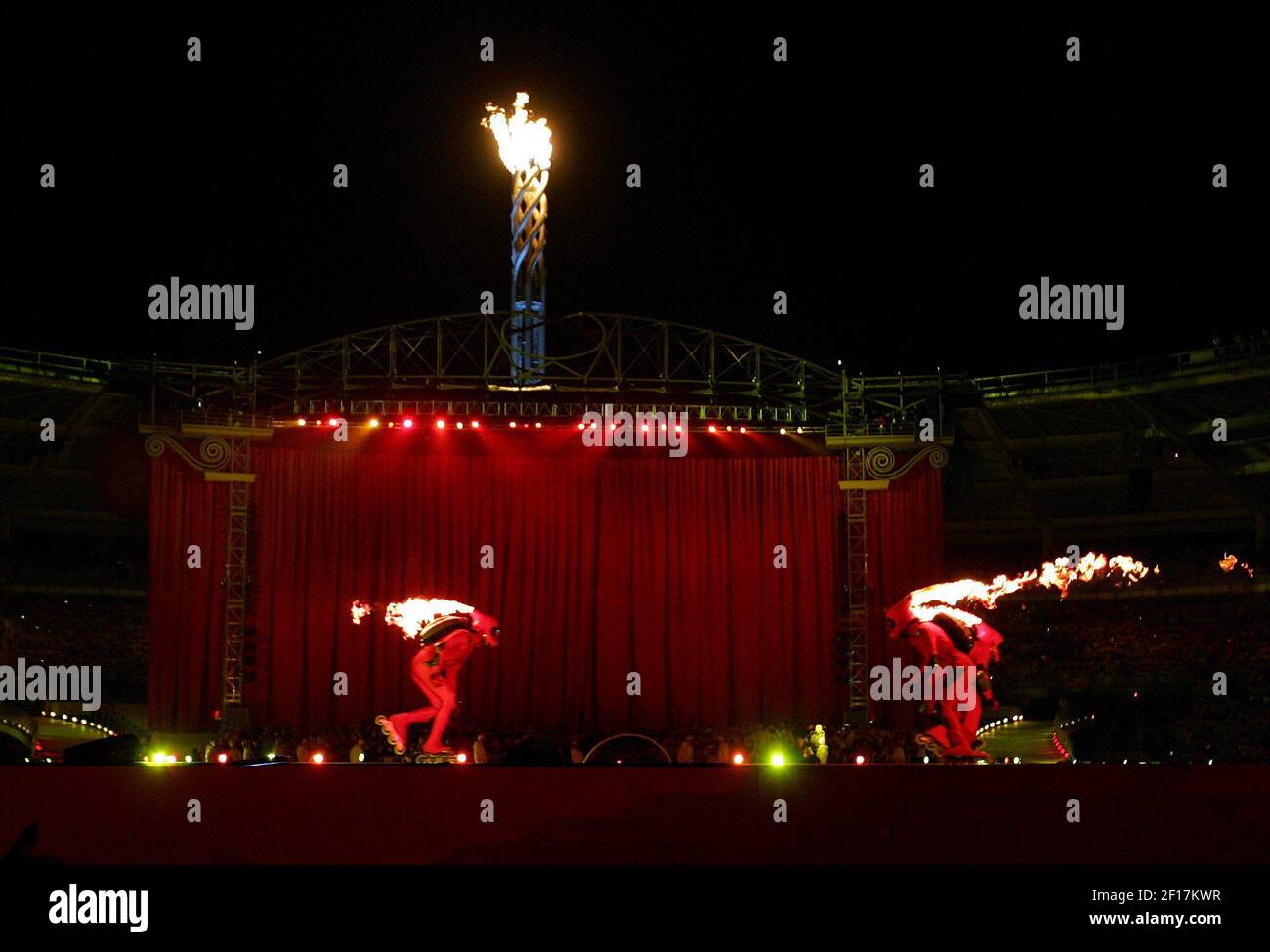 The Olympic torch glows above performers on stage at the Olympic ...