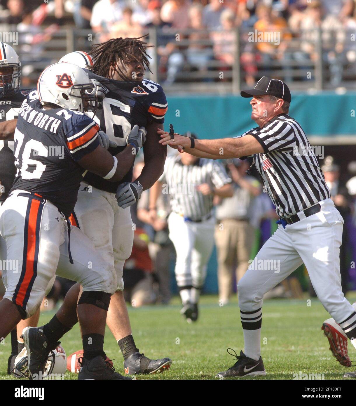 An official and teammates restrain Auburn's tackle Troy Reddick after ...