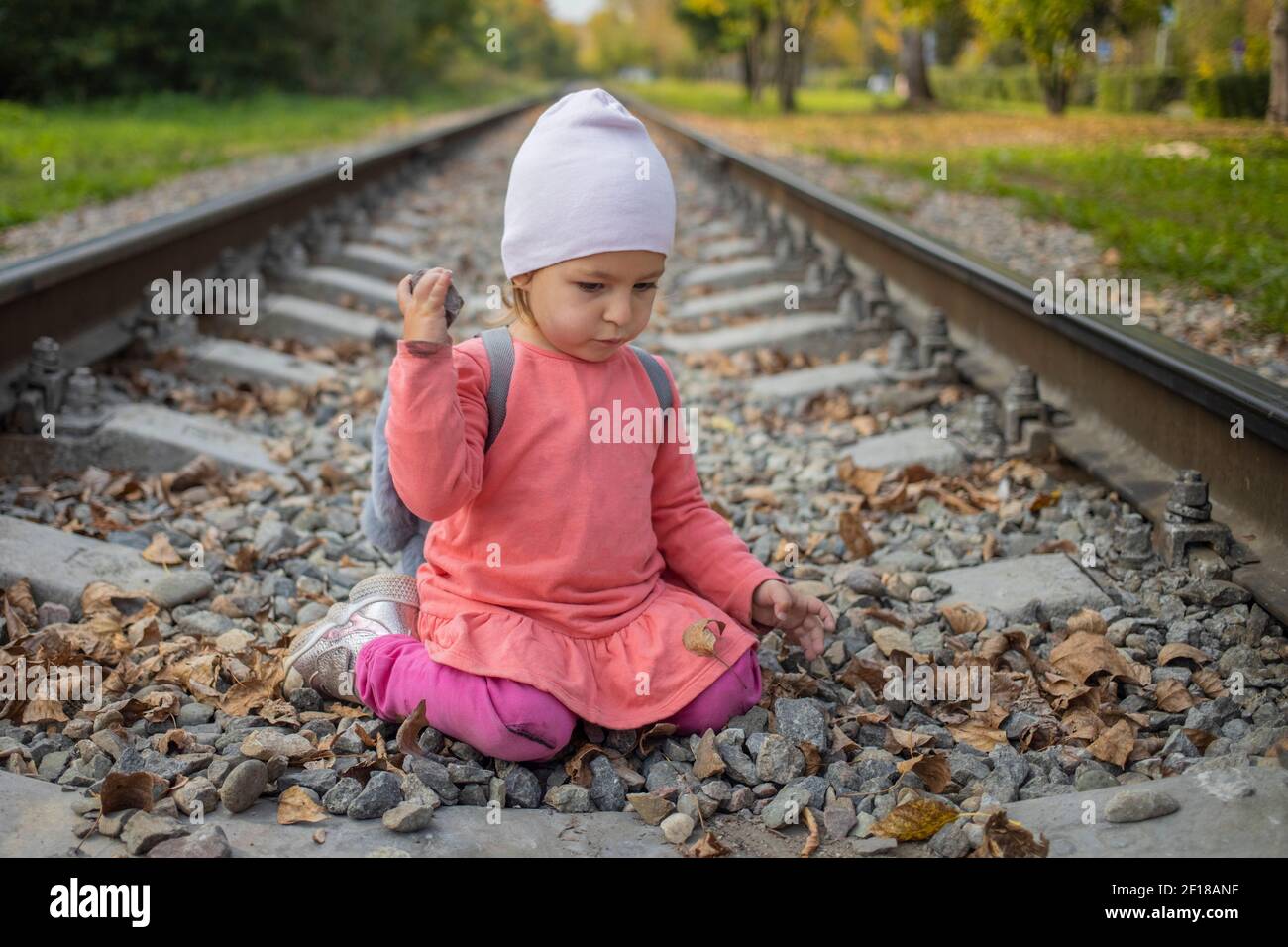 portrait of little girl sitting on the train tracks in the forest Stock ...