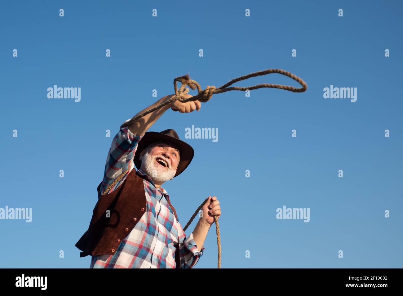 Old western cowboy with lasso rope. Bearded wild west man with brown ...