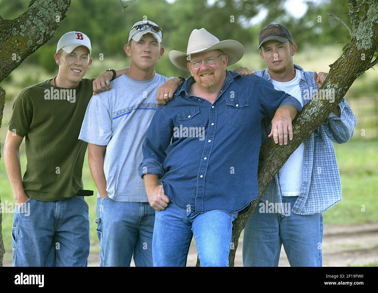 Glen Stephens, with cowboy hat, stands with his sons Tanner, left ...