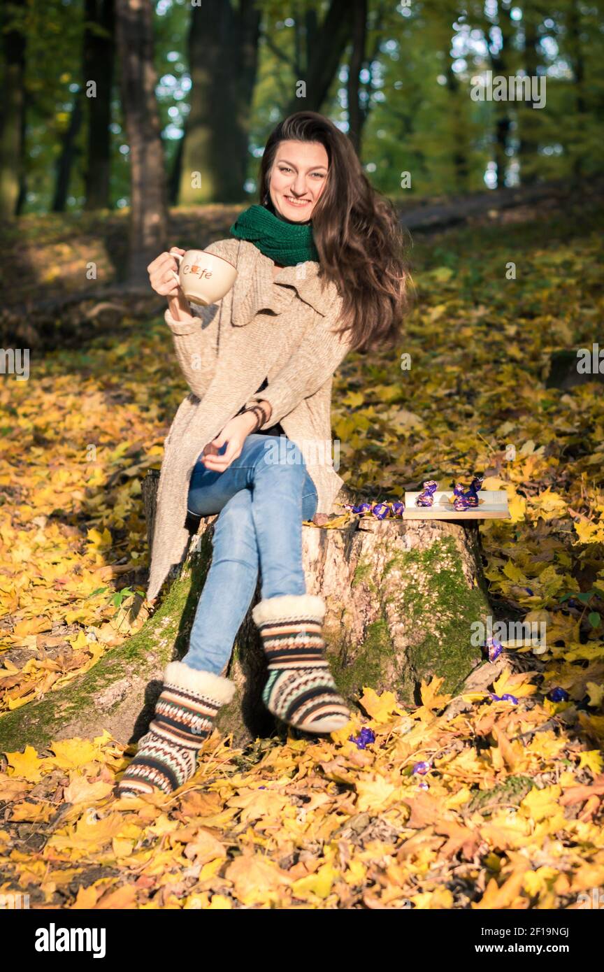 Girl sitting on tree stump Stock Photo - Alamy