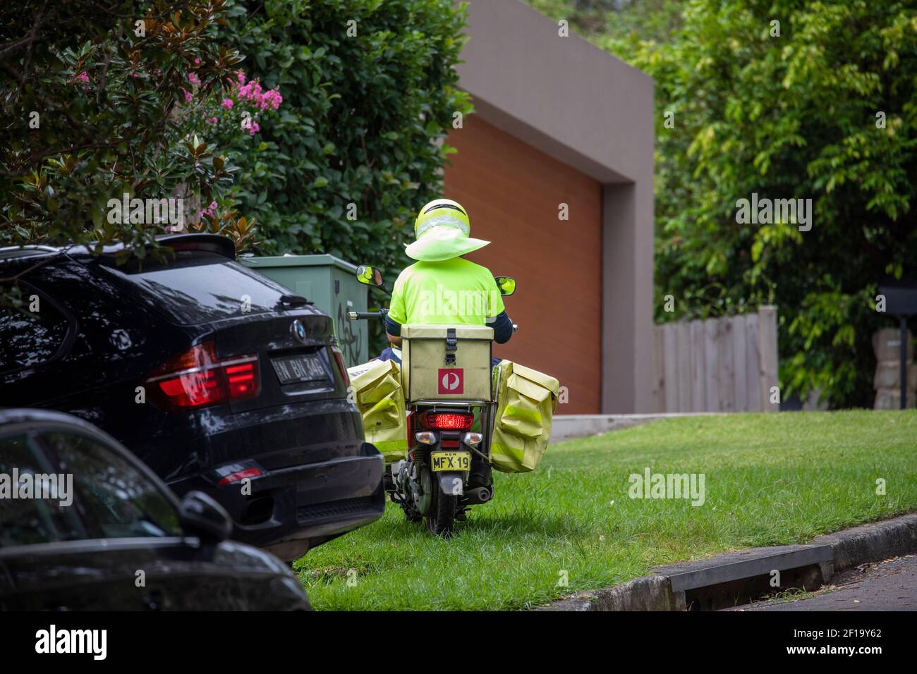 Australia postman riding motorbike delivers mail and letters to a ...