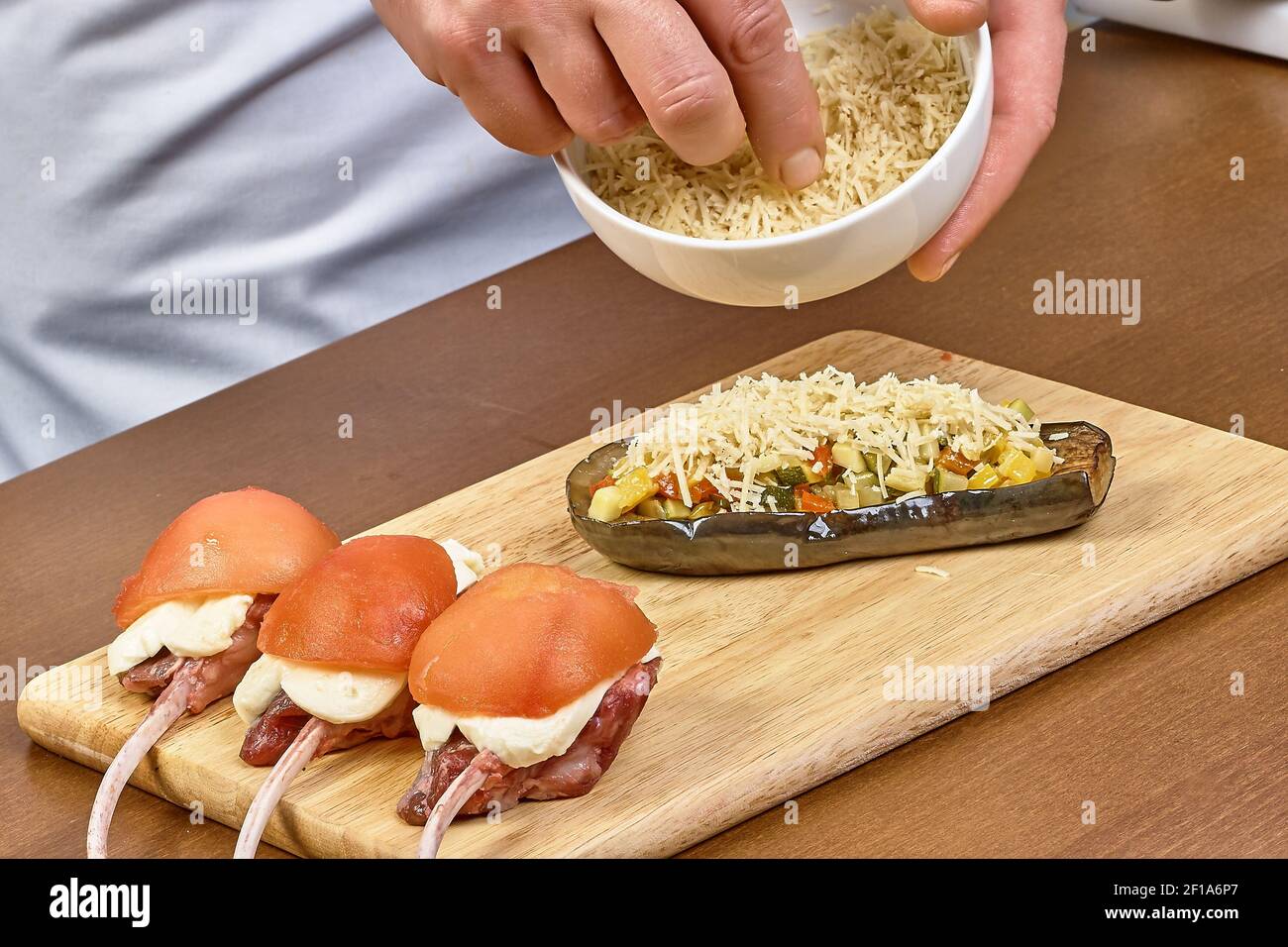 Cook sprinkle with cheese stuffed eggplant Stock Photo - Alamy