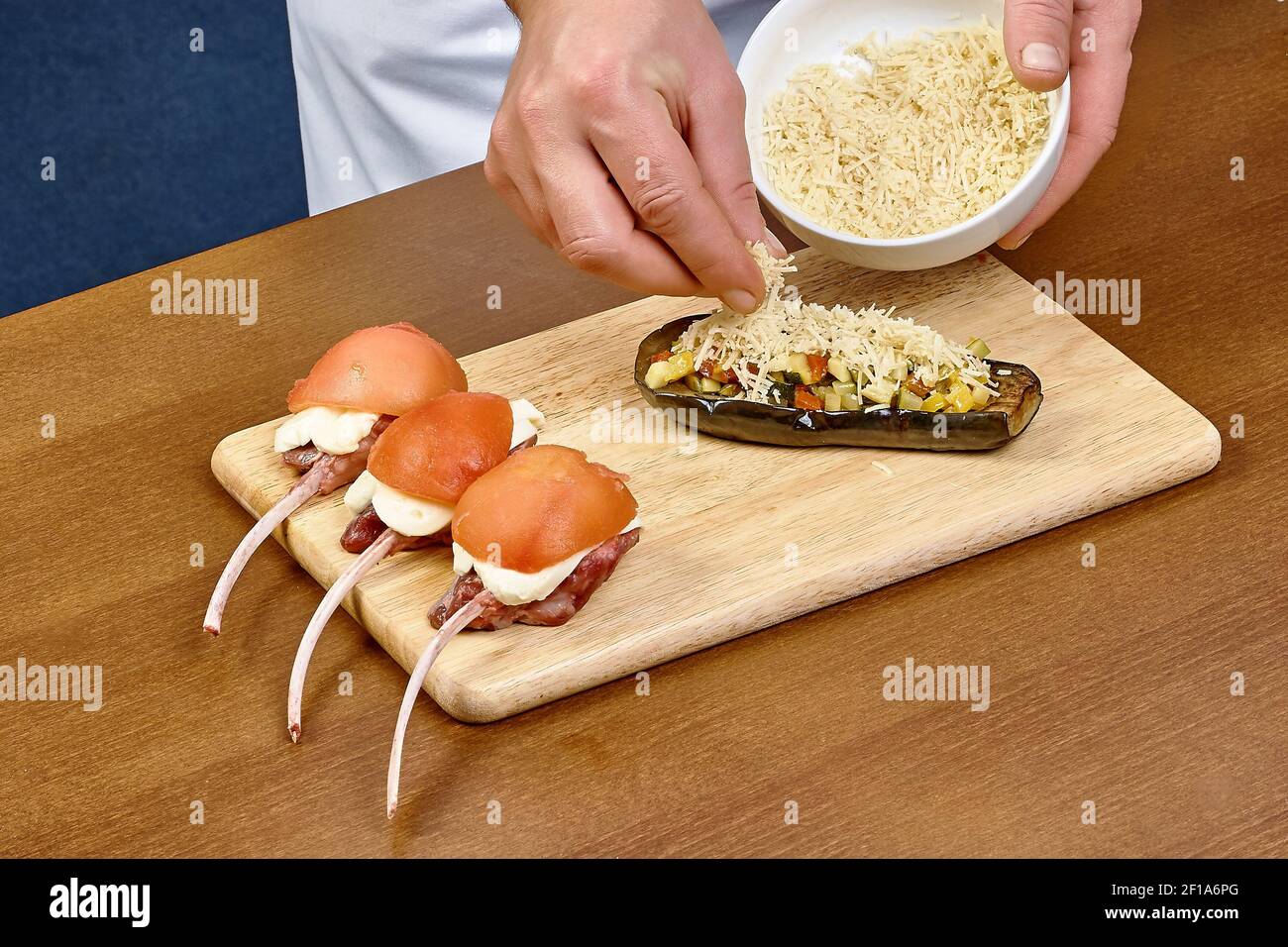 Cook sprinkle with cheese stuffed eggplant Stock Photo - Alamy