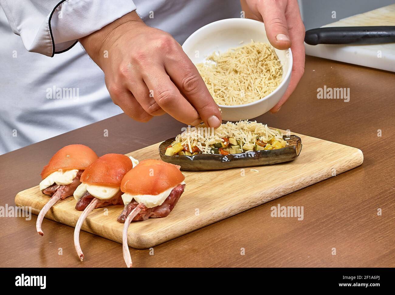 Cook sprinkle with cheese stuffed eggplant Stock Photo - Alamy