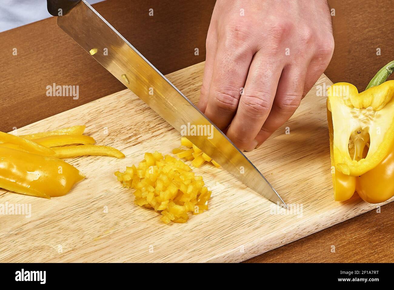 Closeup on hands cutting yellow pepper on professional kitchen Stock ...
