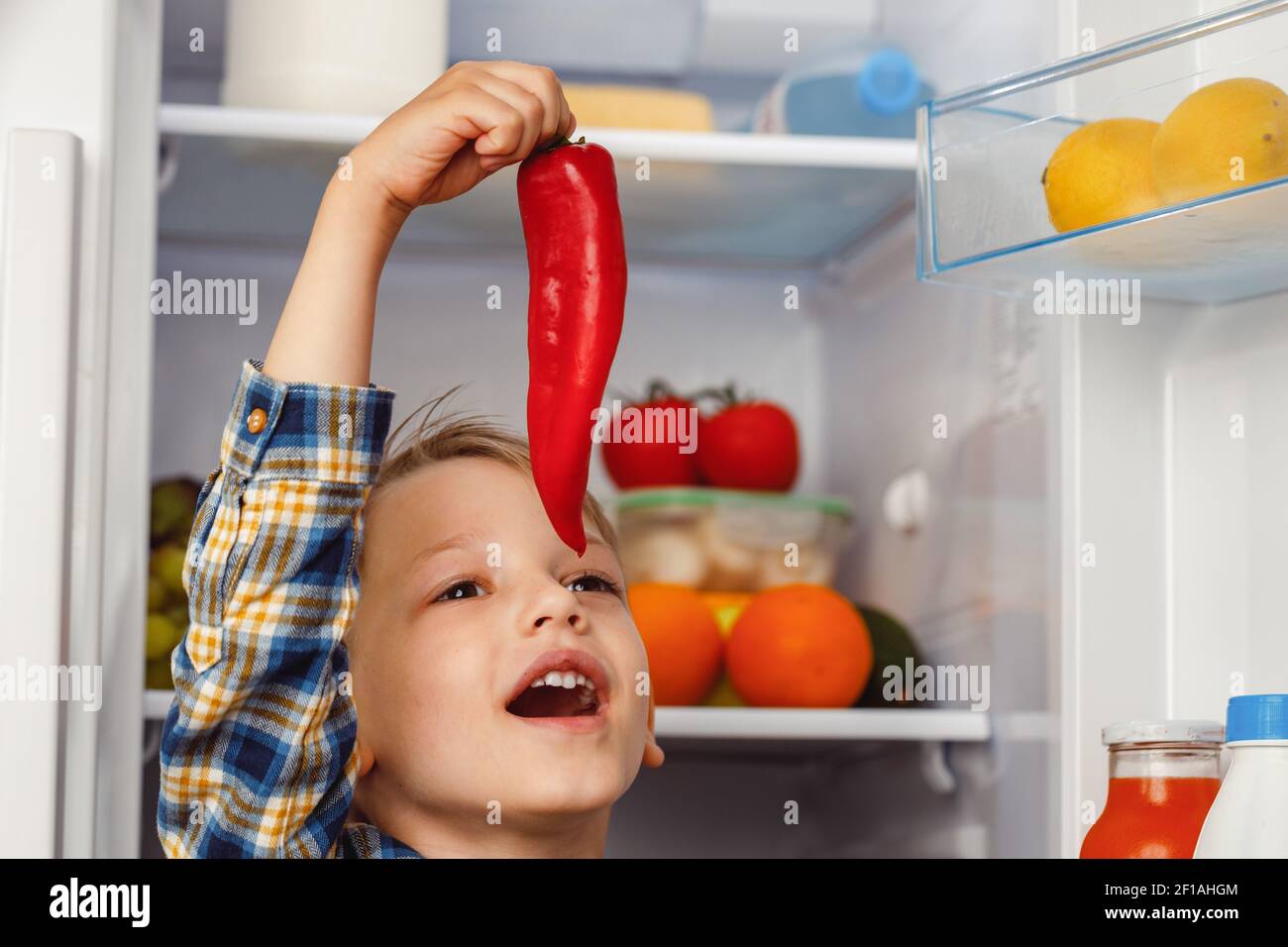 Little boy standing near the open fridge Stock Photo - Alamy