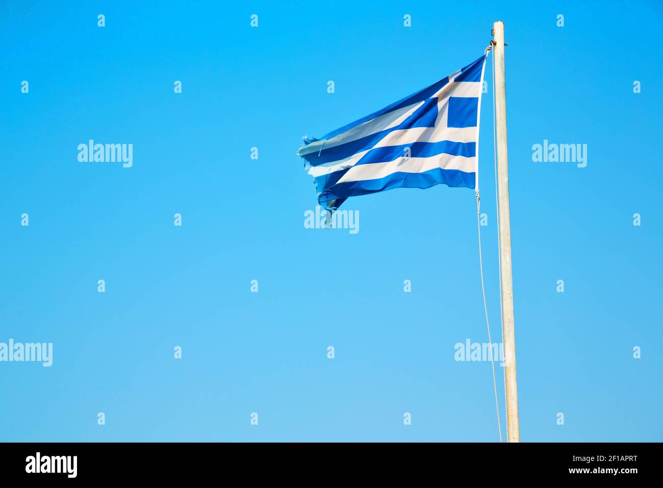 Waving greece flag in the blue sky and flagpole Stock Photo - Alamy