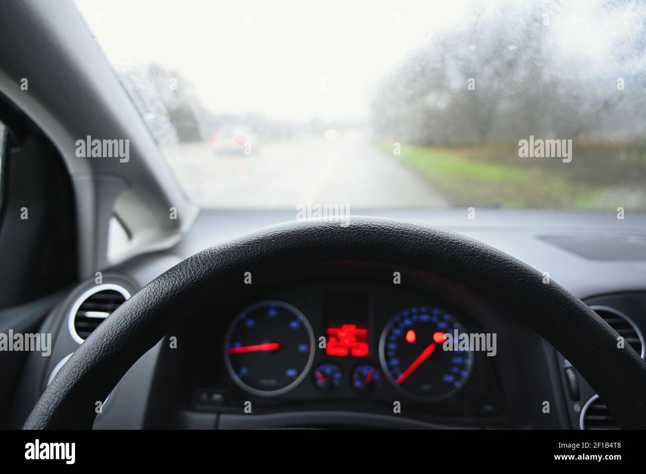 View from the driver - car interior with steering wheel and dashboard ...