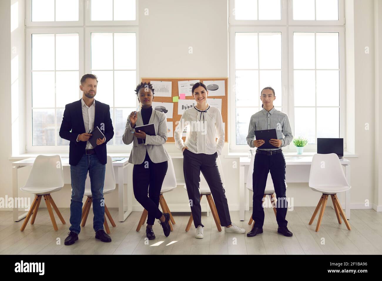 Group portrait of multiracial office workers posing in front of the ...