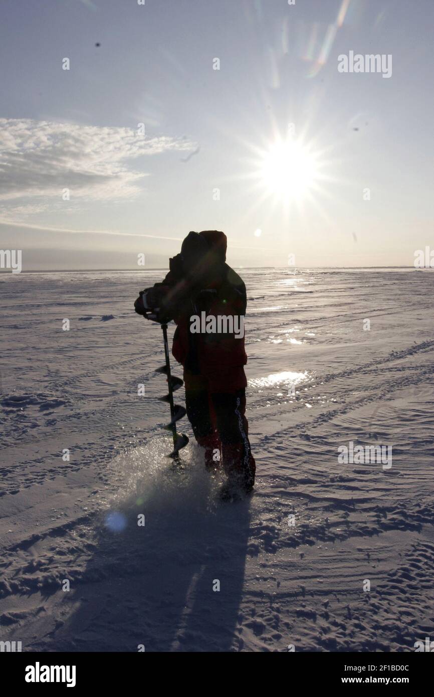 Fishing guide Tony Roach drills holes recently on and near a reef on ...
