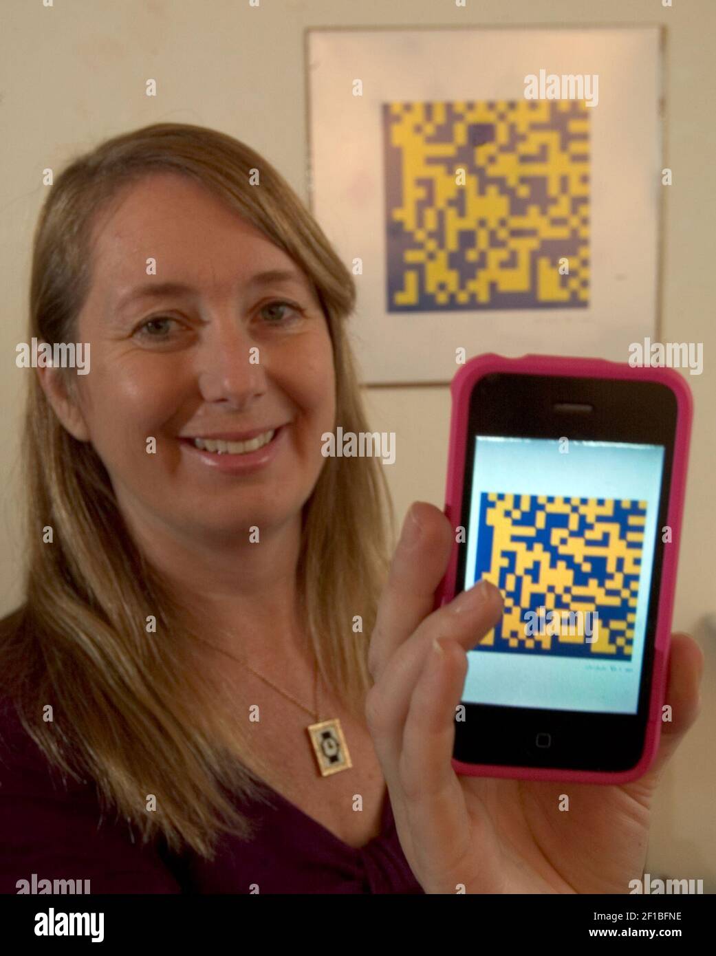 Michelle Pred uses her iPhone to show a photo of the original art print ...