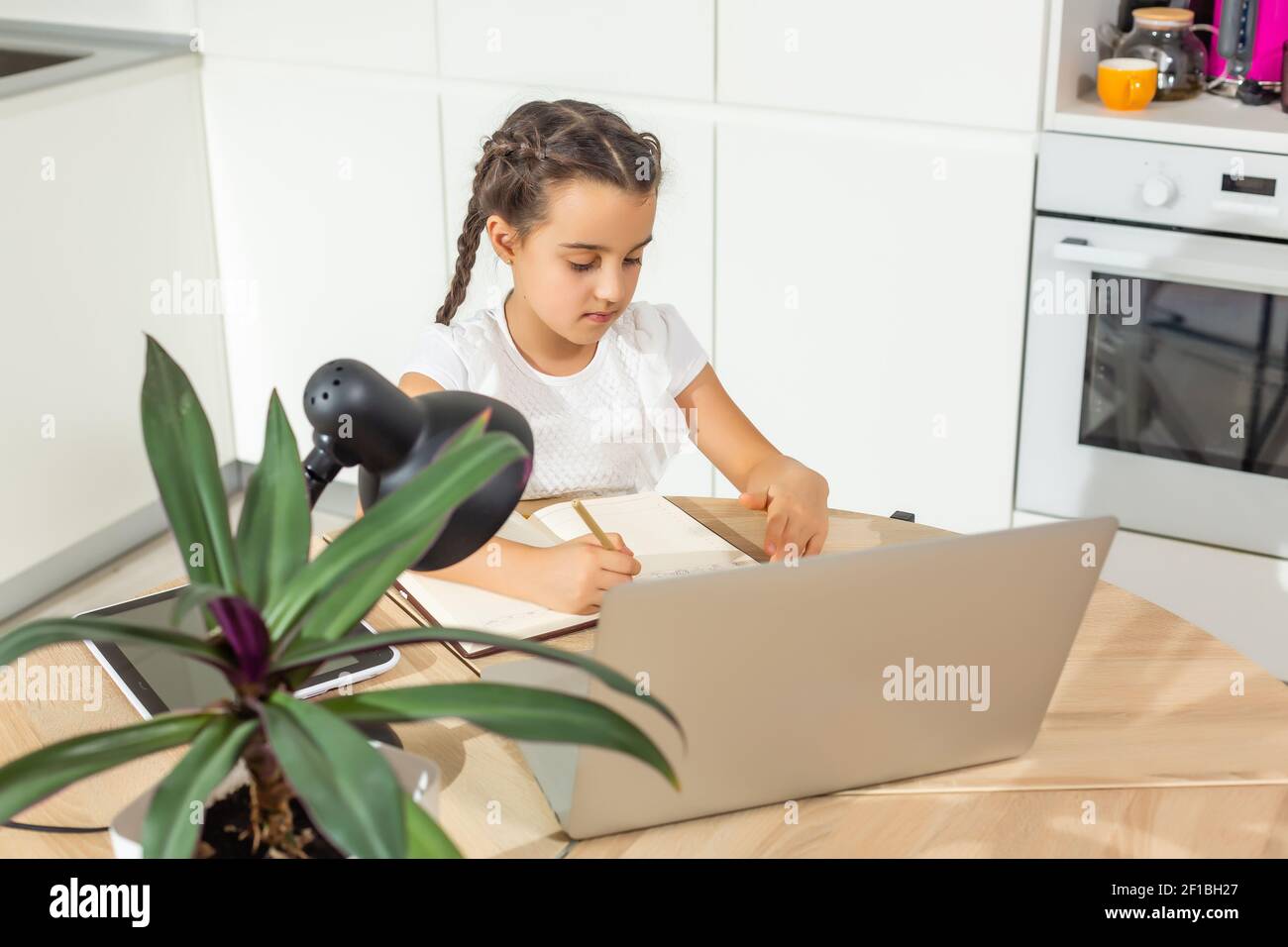 Kids distance learning. Cute little girl using laptop at home ...