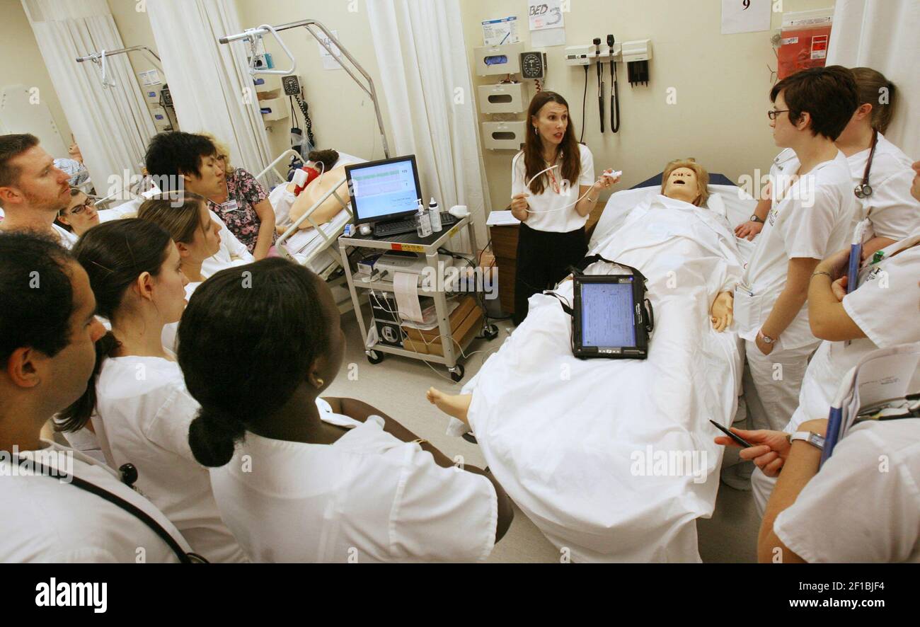 Nursing instructor Betsy Guimond stands by a bed with a mannequin used ...