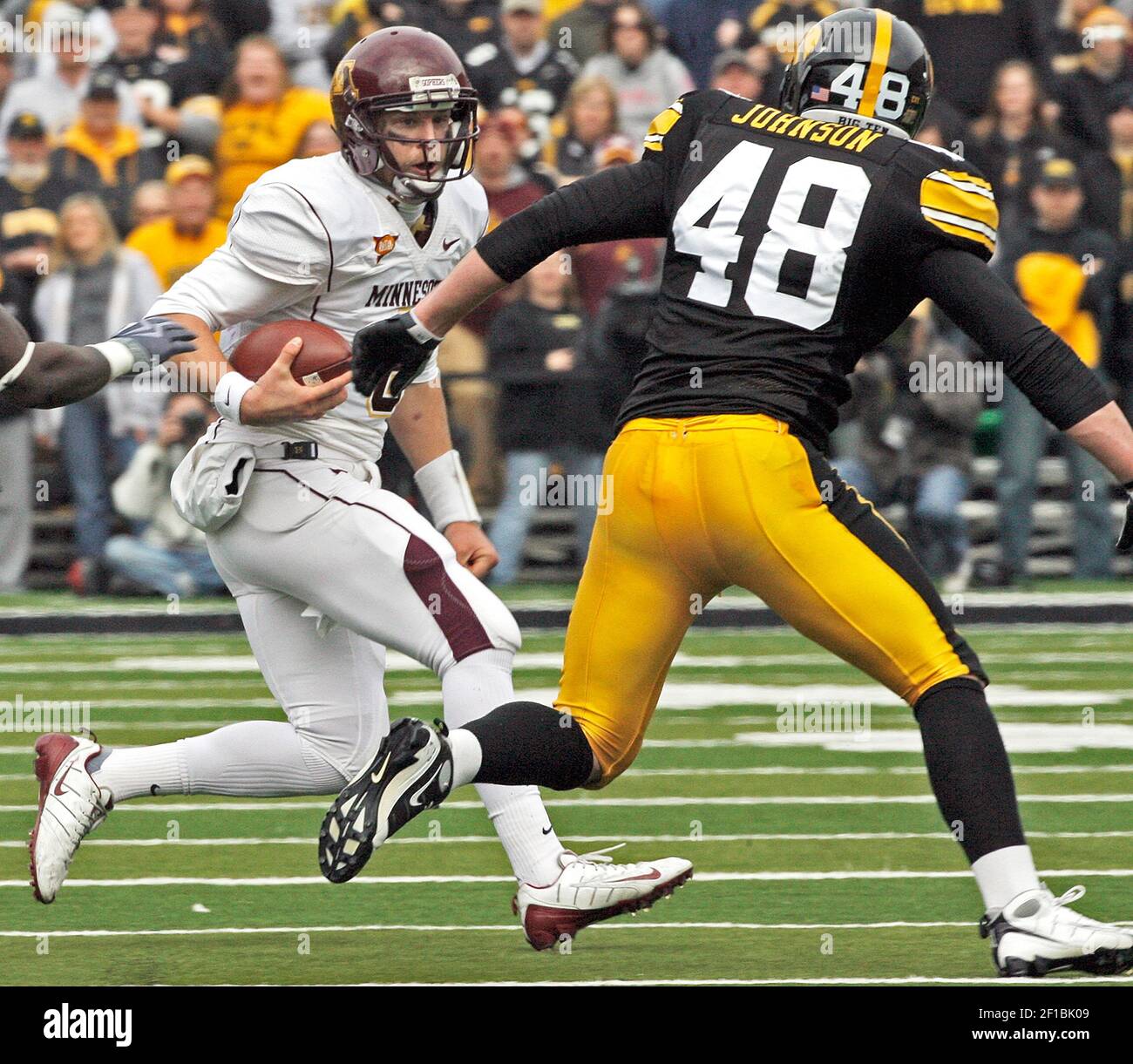 Iowa defender Troy Johnson (48) pressures Minnesota quarterback Adam ...