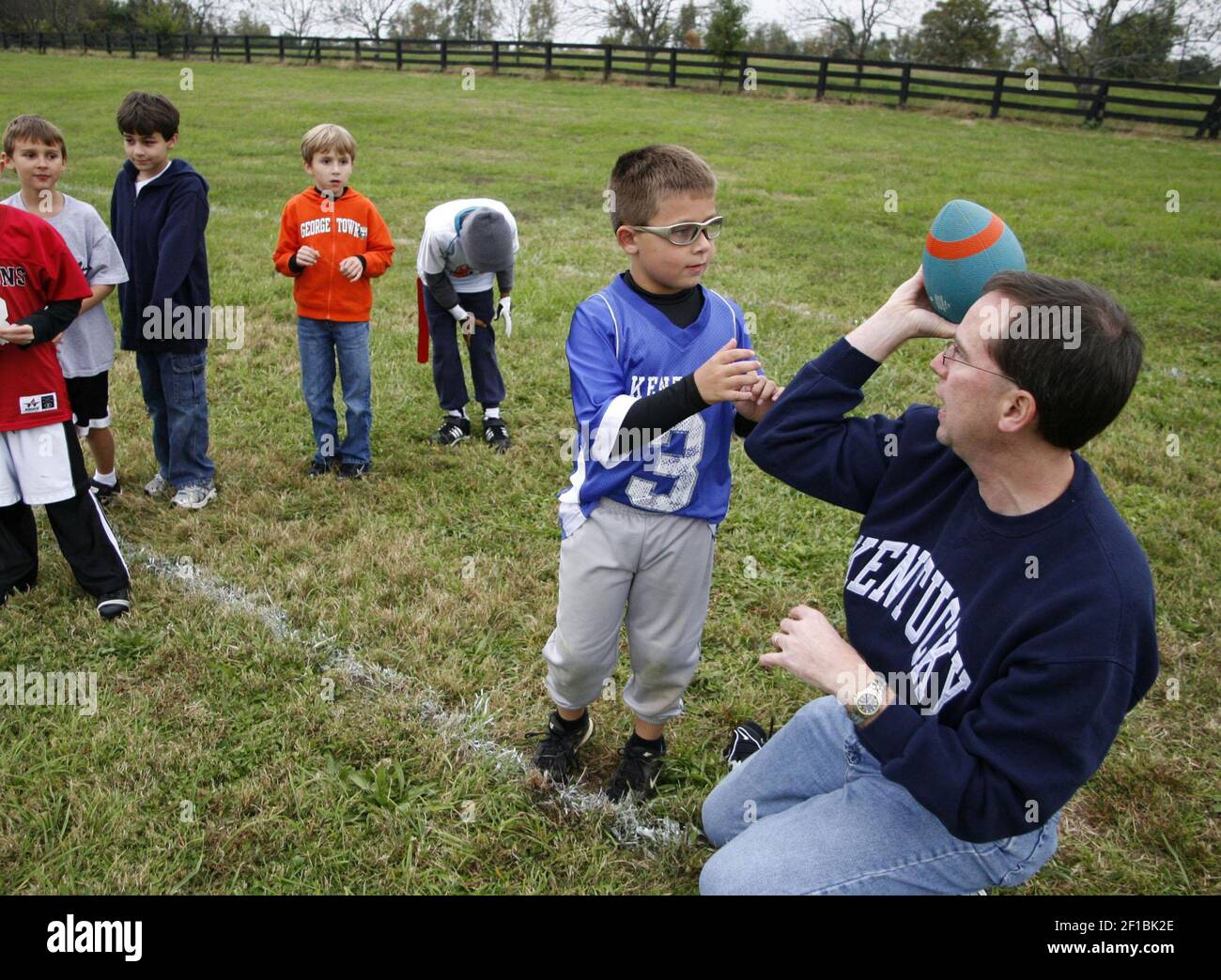 David Todd gives a pointer to Brody Solomon, 8, during flag-football ...