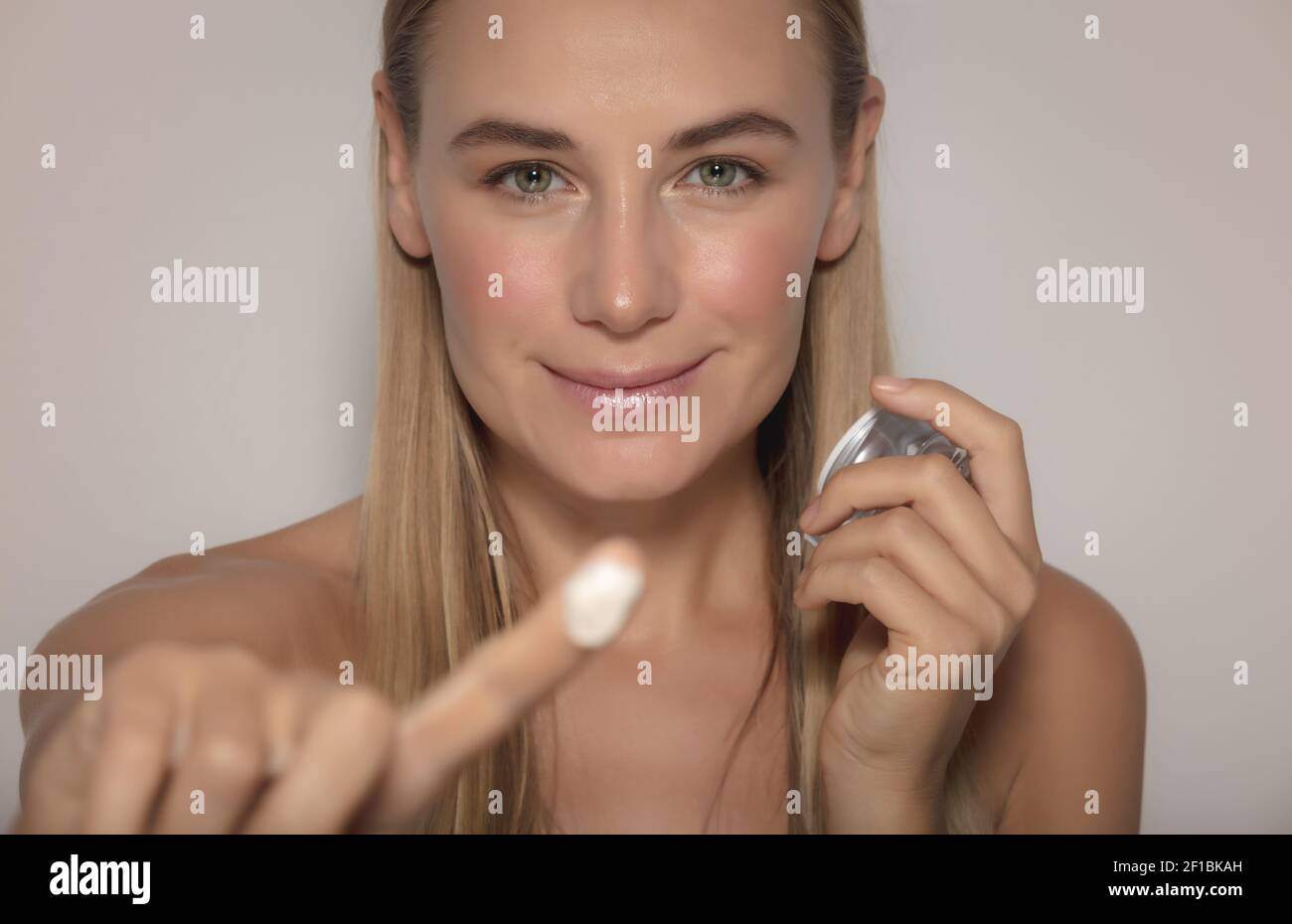 Portrait of a Pretty Woman Isolated on a Beige Background Applying Face ...