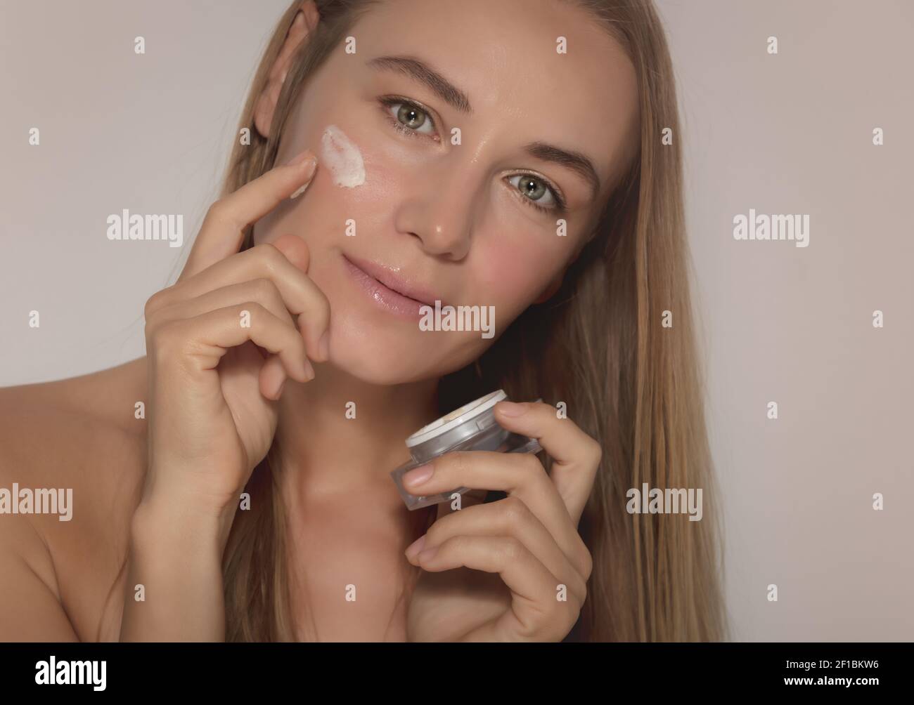 Portrait of a Nice Female Model Using Moisturizing Cream. Isolated on ...