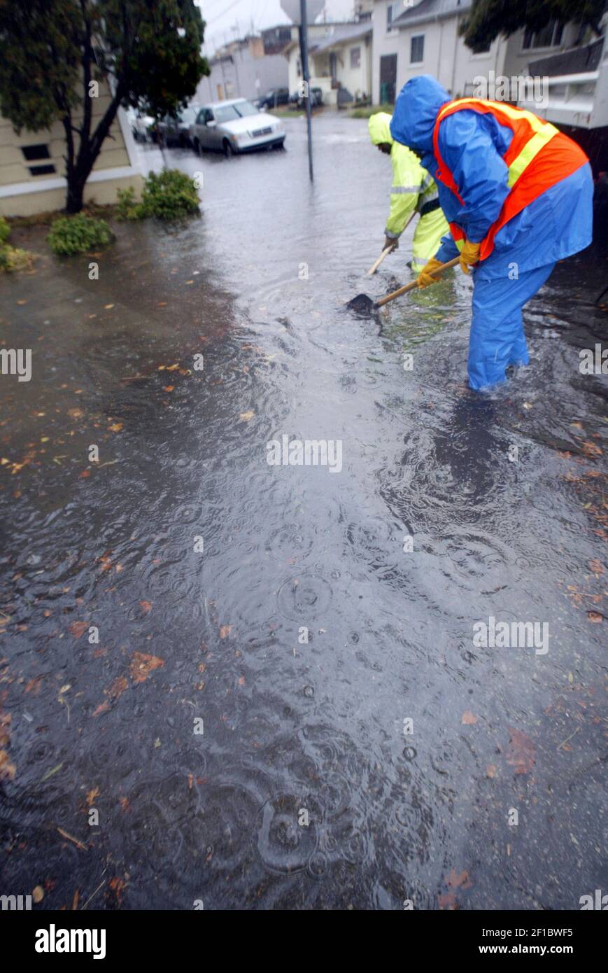 Oakland Public Works employees unclog a gutter drain in Oakland ...
