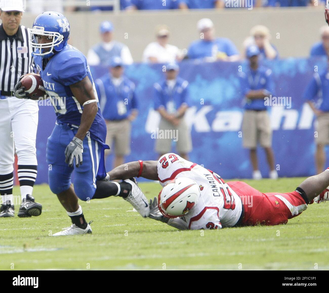 Kentucky's Derrick Locke breaks a tackle by Louisville's Antwon Canady ...
