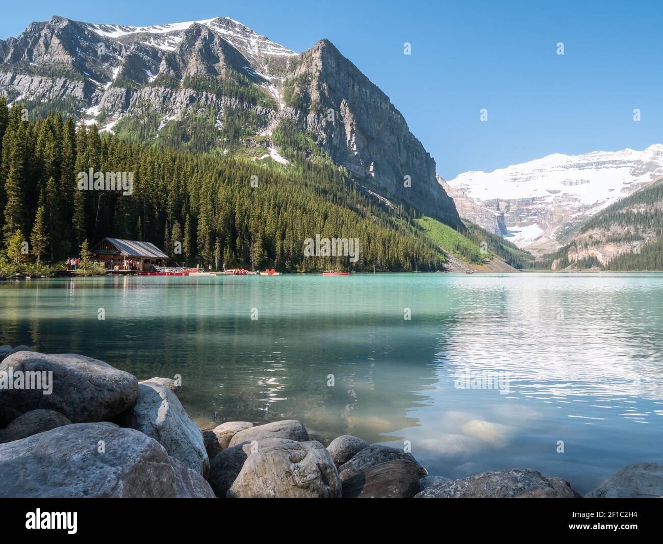 Turquoise glacier lake with boathouse surrounded by mountains, shot in ...