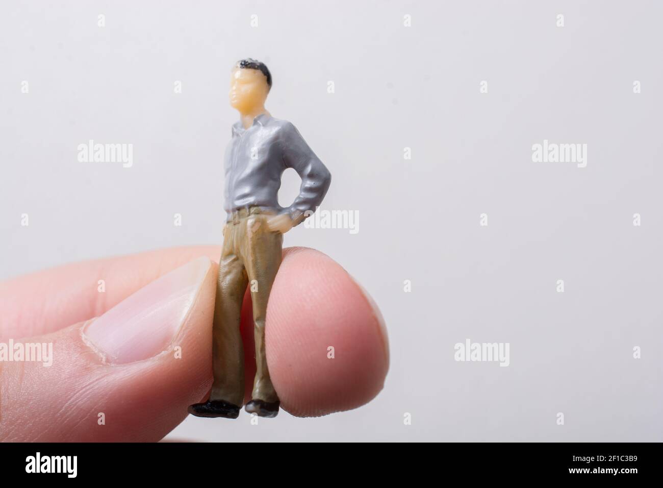Tiny figurine of man miniature model in hand Stock Photo - Alamy