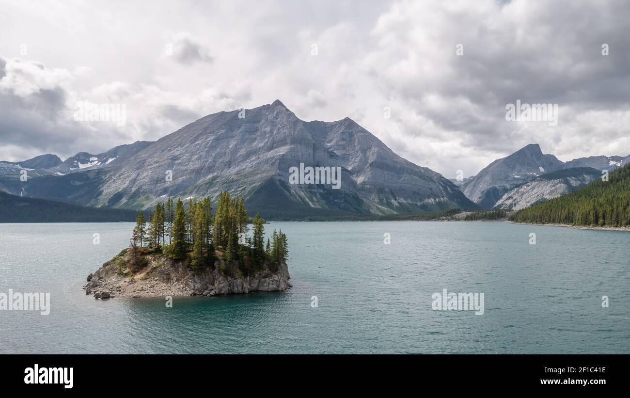 Isolated island on alpine lake with mountains in backdrop. Shot at ...