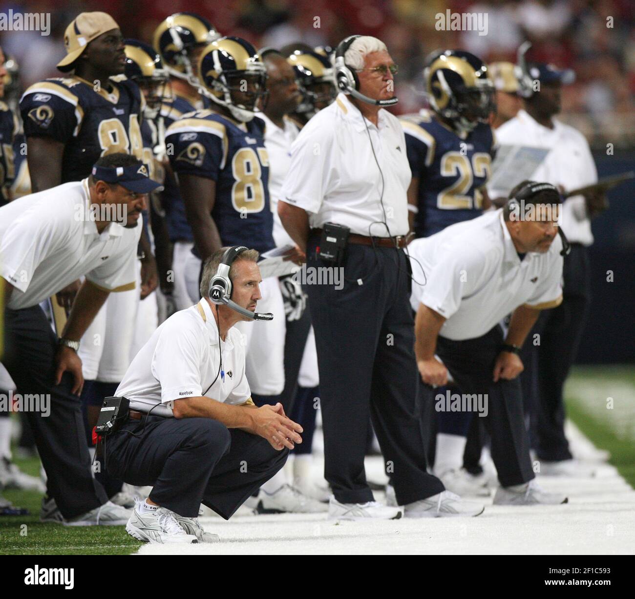 St. Louis Rams head coach Steve Spagnuolo (squatting at left) watches a ...
