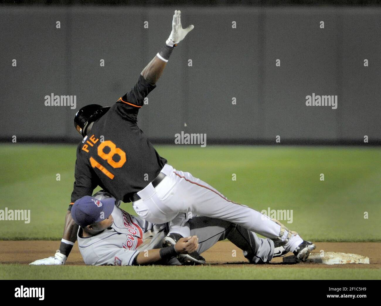 Baltimore Orioles' Felix Pie (18) falls over Cleveland Indians second ...