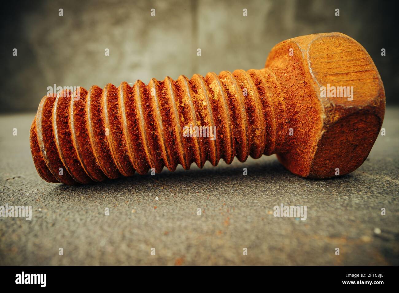 Old rusty bolt on grey background macro Stock Photo - Alamy
