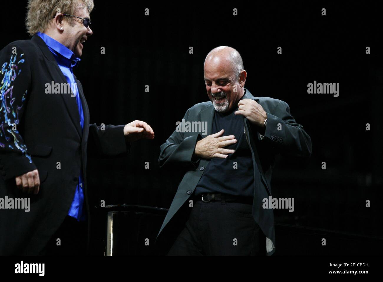 Billy Joel, right, wipes his shirt clean while having a laugh with ...
