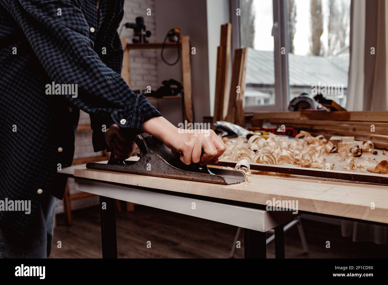 Carpenter's hands planing a plank of wood with a hand plane Stock Photo ...