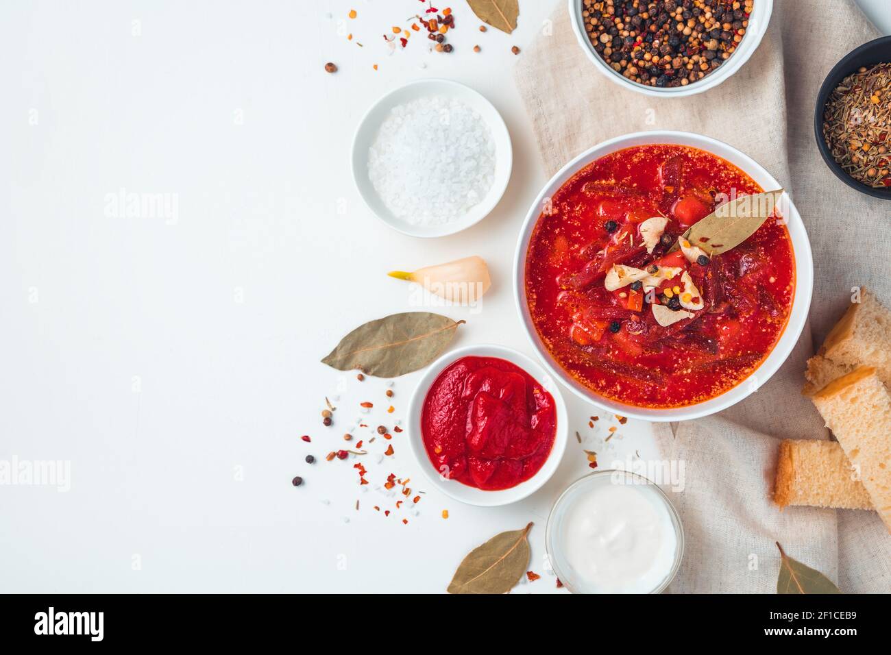 Delicious borscht with garlic and bay leaf on a white background. Side ...