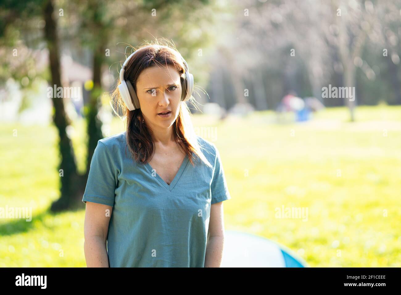 beautiful woman listening to music with music headphones in a park in ...