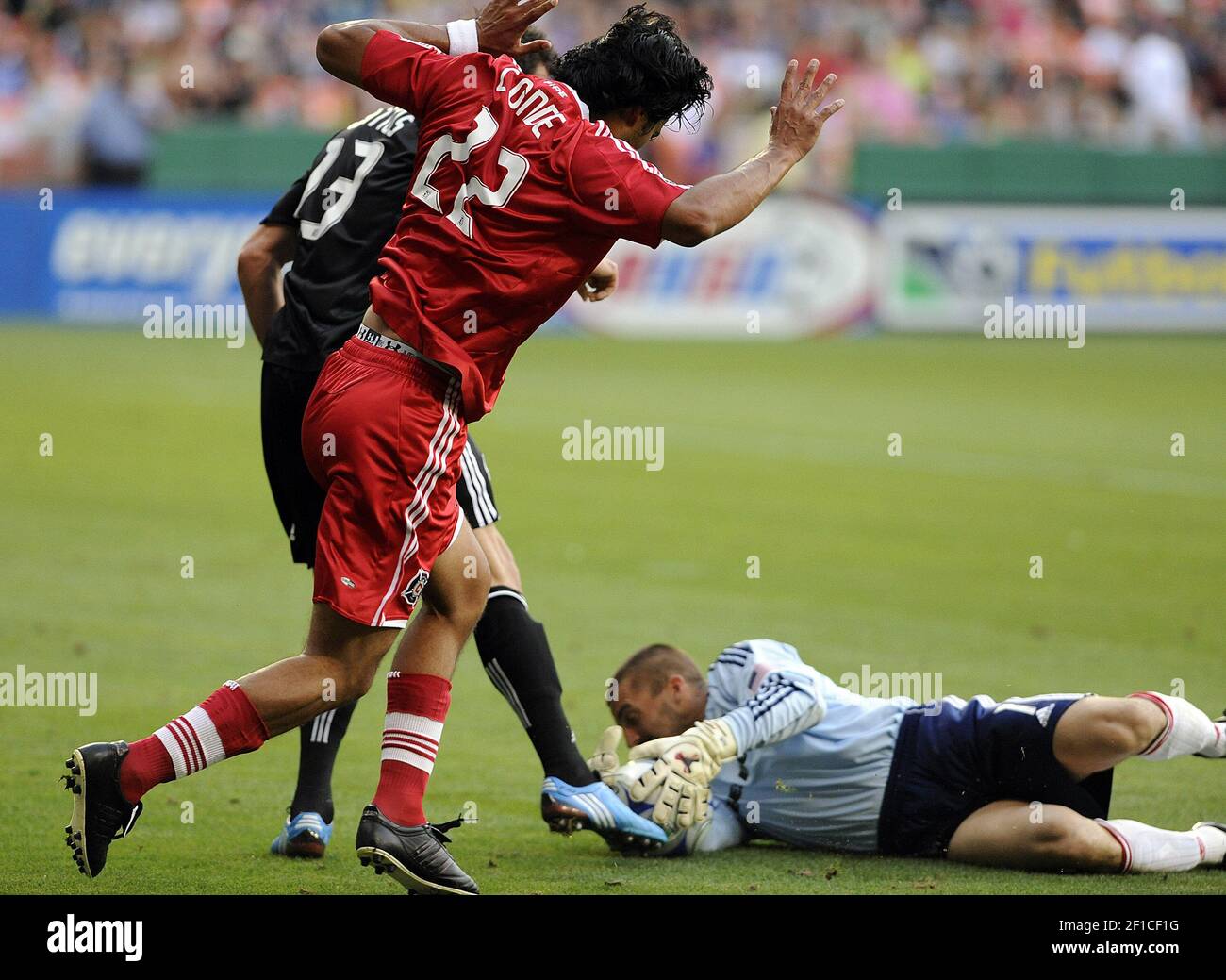 Chicago Fire goalkeeper Jon Busch, on ground, makes a save with D.C ...
