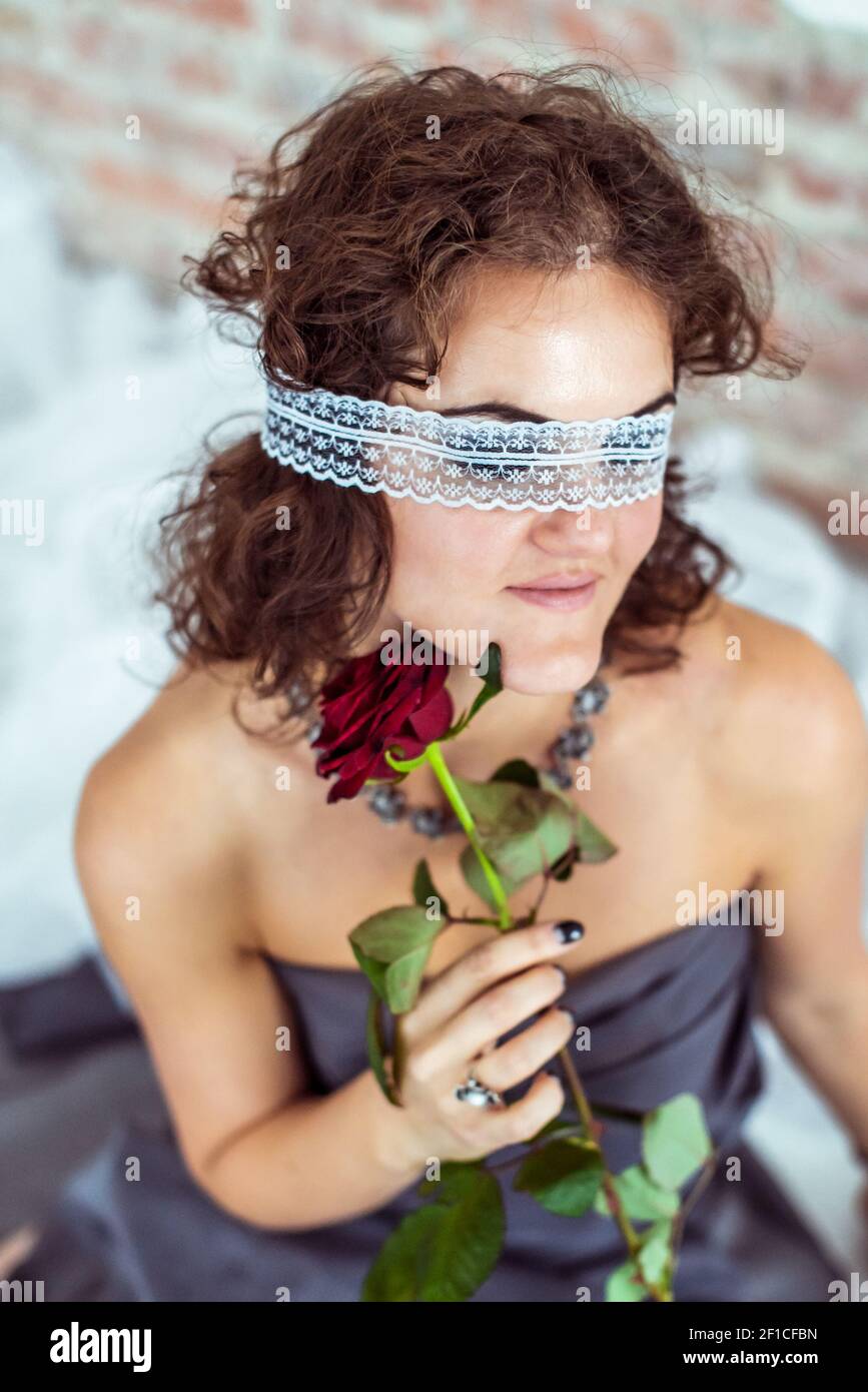 Beautiful woman smells red rose Stock Photo - Alamy